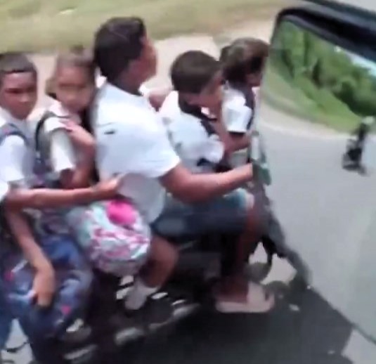 Onlookers stunned as biker spotted taking five kids ‘to school’ on same ...