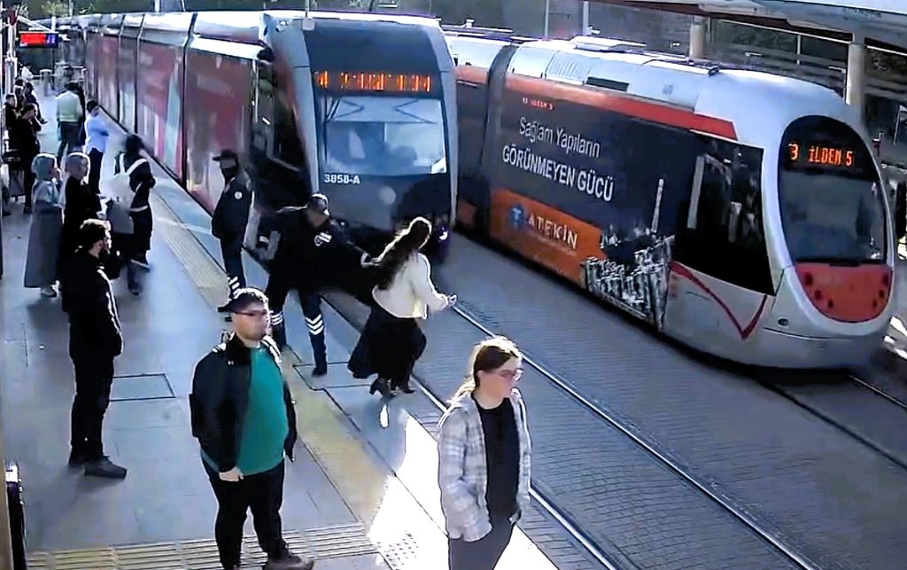 Railway worker pulls distracted woman away from path of moving train in ...